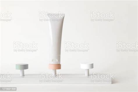 모형 화장품 튜브는 흰색 배경 전면 보기에 받침대에 서있습니다 스킨 케어 컨셉 모이스처라이저와 빈 공간을 갖춘 연단 가꿔주기에
