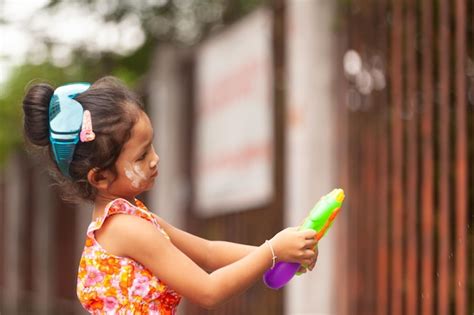 Premium Photo Side View Of Cute Girl Spraying Water With Squirt Gun