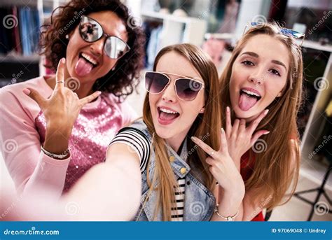 Le Ragazze Graziose Che Indossano Gli Occhiali Da Sole Che Imbrogliano