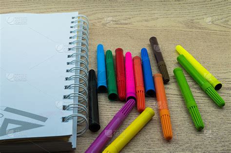 书和神奇的彩色笔在木制上。