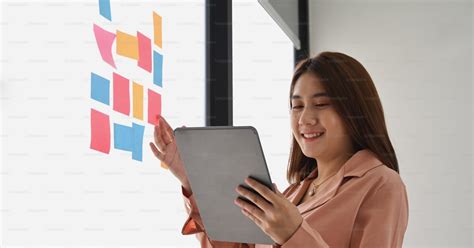 디지털 태블릿을 들고 유리 벽에 스티커 메모를 읽는 자신감 있는 사업가 사진 Unsplash의 그것의 게시 이미지