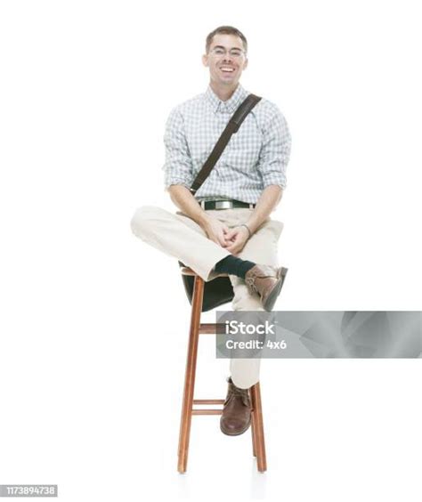 전체 길이한 남자 만전면 2029 세 성인 잘 생긴 머리짧은 머리 백인 남성젊은 남자 앉아미소행복쾌활 하 고 가방을 들고 가방의자에 앉아 흰색 배경 앞에 휴식 20 29세에