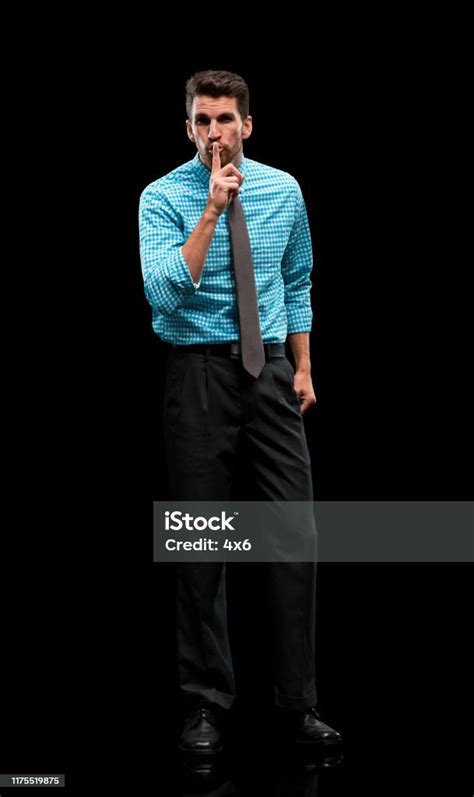 한 남자 만 한 사람 전체 길이 전면 3039 세의 성인 잘 생긴 사람들의 카메라를보고 백인 남성 젊은 남성 사업가 비즈니스 맨 은 양복을 입고 입술에 손가락을 보여주는