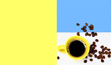 커피의 노란색 컵 그들은 창조적 인 노란색 흰색 파란색 배경의 다양한 천연 커피 콩입니다 모닝 커피 아침 식사의 개념 공간을 복사합니다 맨 위 보기 커피잔에 대한 스톡 사진