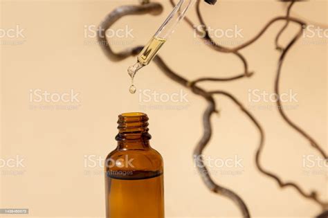 혈청 또는 오일의 열린 화장품 병과 베이지 색 자연 배경에 피펫 얼굴 피부 관리 아로마 오일 천연 바이오 화장품의 개념 유기농