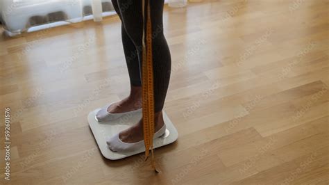 Woman Measuring Body Weight On Weighing Scale At Home Close Up Of A Woman Legs Measuring Weight