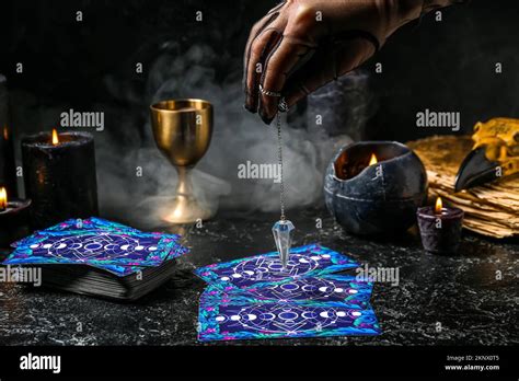 Fortune Teller Using Pendulum And Tarot Cards To Read Future On Dark