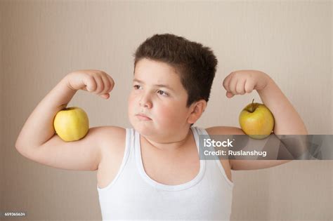 T셔츠에 뚱 보 소년 그의 팔 뚝에 근육과 사과 보여줍니다 가득 찬에 대한 스톡 사진 및 기타 이미지 가득 찬 건강에 좋지 않은 음식 건강한 생활방식 Istock