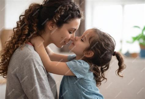 Premium Photo A Mother And Daughter Kiss In The Living Room
