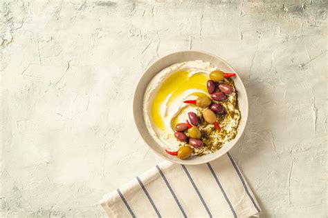 인기있는 중동 전채 라브네 또는 라바네 올리브 오일 히솝 또는 자타르를 곁들인 부드러운 흰색 염소 우유 치즈 회색 테이블에 올리브 상단 보기 복사 공간이있는 평평한 평신도