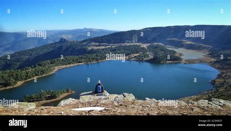 Areal Shot O A Beautiful Tarn With A Person Sitting On The Top Of The