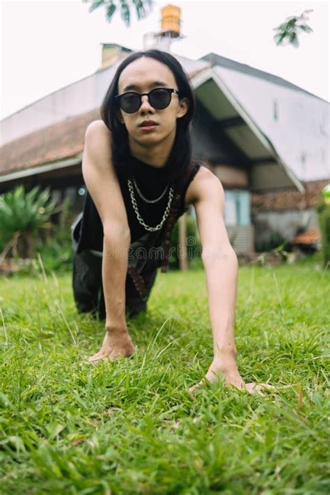 An Asian Woman With Sunglasses And A Black Shirt Posing And Crawling