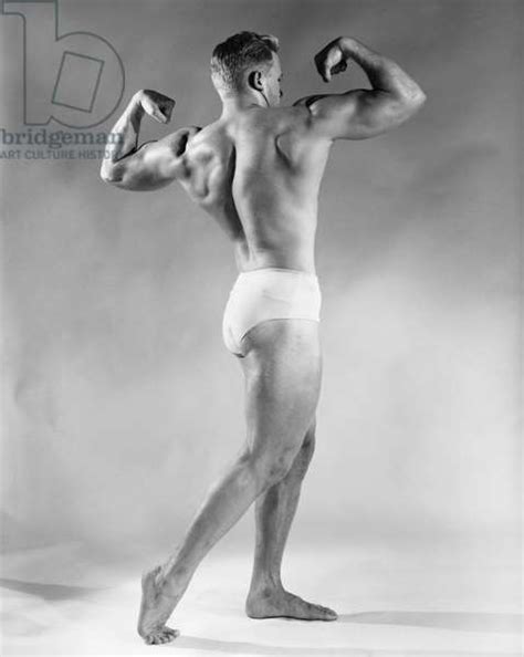 Image Of Rear View Of A Male Body Builder Flexing His Muscles