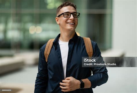 배낭을 메고 안경을 쓴 젊은 유럽 남자 학생이 라이프 스타일을 즐기고 여유 공간을 보면서 기뻐 충격을 받았습니다 학생에 대한 스톡 사진 및 기타 이미지 Istock