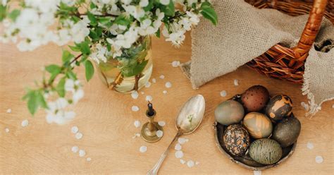 행복한 부활절 플랫 레이 바구니가 있는 소박한 나무 테이블에 봄 꽃이 있는 현대 부활절 달걀 세련된 회색 돌과 녹색 부활절 달걀은 카케이드 차의 천연 염료로 칠해져