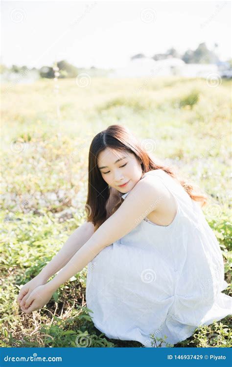 Portrait Of Young Asian Woman Girl Sitting In Garden Stock Image
