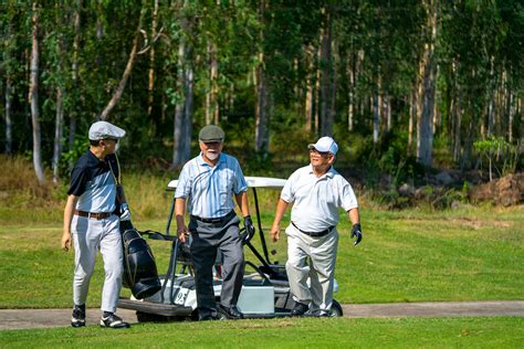 아시아 사업가와 고위 Ceo가 컨트리 클럽에서 골프 페어웨이의 홀 근처에서 골프를 치고 있다 건강한 노인 골퍼는 친구들과 야외