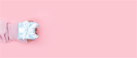 여러 가지 색의 색종이와 파스텔 핑크 배경에 빨간 활과 현재 상자를 들고 여자 손 플랫 레이 스타일입니다 생일에 대한 스톡 사진