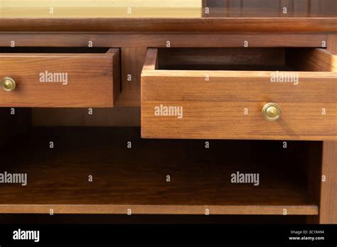 Two Open Wooden Drawers On A Vintage Desk With Brass Knobs Empty