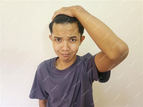 고립된 흰색 배경에서 대머리가 되고 머리카락이 빠지는 아시아 남자의 충격적인 얼굴 프리미엄 사진