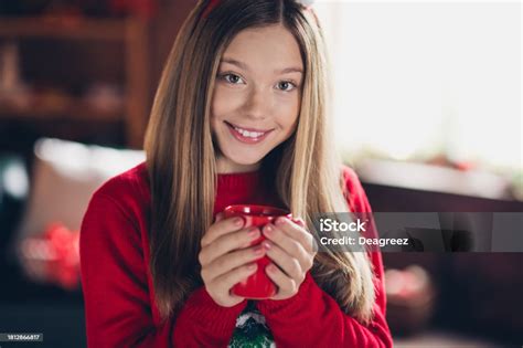 집에서 크리스마스 분위기 추운 날씨 분위기를 즐기는 빨간 컵 차 또는 에그 노그를 들고 귀여운 미소 십대 소녀 젊은이의 근접 촬영 사진 12 13세에 대한 스톡 사진 및