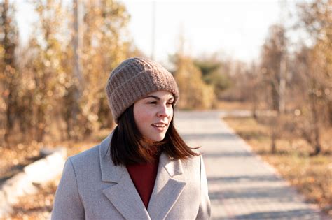 니트 모자와 코트를 입은 웃는 소녀가 가을 황량한 공원 호수의 자갈길을 따라 걷는다 30 34세에 대한 스톡 사진 및 기타 이미지 30 34세 걷기 겨울 Istock