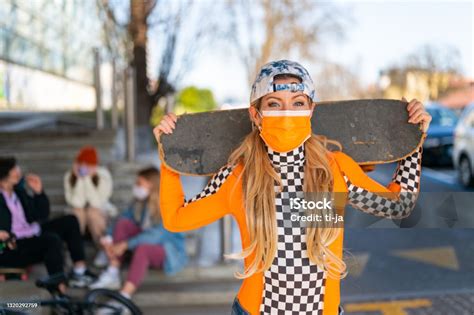 그녀의 목 뒤에 스케이트 보드를 들고 보호 얼굴 마스크를 가진 젊은 여성의 초상화 16 17 살에 대한 스톡 사진 및 기타 이미지 16 17 살 20 24세 30