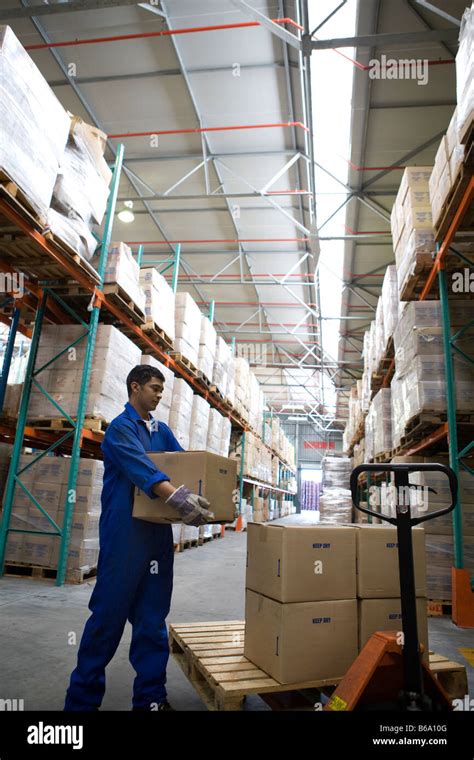 Worker Stacking Boxes In Warehouse Stock Photo Alamy