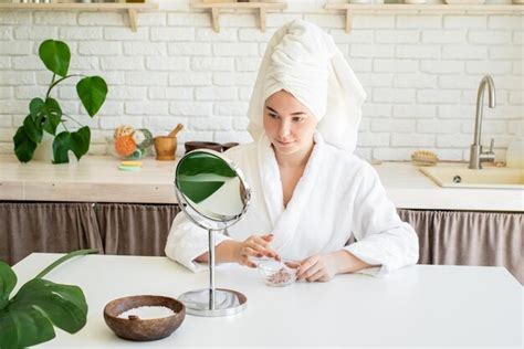 premium photo woman applying face mask in front of the mirror