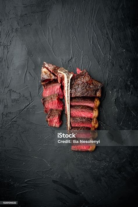 슬라이스 중간 희귀 구운 쇠고기 스테이크 T 뼈 또는 포터 하우스 컷 검은 돌 배경에 상단 보기 플랫 레이 텍스트복사 공간 티본 스테이크에 대한 스톡 사진 및 기타 이미지