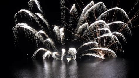 Premium Photo Firework Display At Night On The Water
