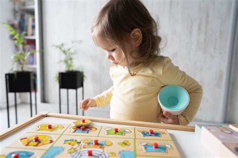 나무 퍼즐과 큐브 장난감 조기 아동 발달 및 몬테소리 아이 개념을 가지고 집에서 노는 한 명의 여자 아기 유아 가정 생활에 대한