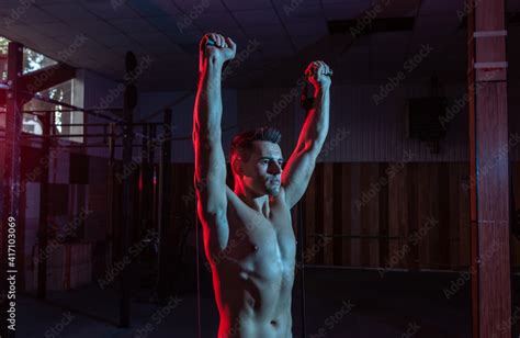 Muscular Powerful Man With Naked Torso Trains With Expander Fitness