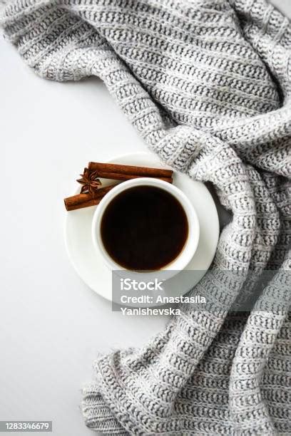계피 스틱과 흰색 배경에 아니스 스타커피 한 잔 스웨터 주위에 겨울 아침 루틴 커피 휴식 공간을 복사합니다 맨 위 보기입니다