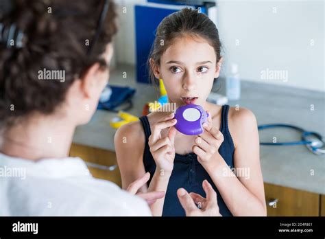 Doctor Instructing A Girl On How To Use An Asthma Inhaler Stock Photo Alamy