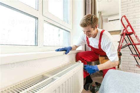 Full Length Shot Of Two Professional Plumbers Workers In Uniform Fixing Or Installing Heating