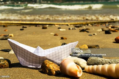 바다 파도를 배경으로 조개와 돌 사이 모래 사장에 종이 보트 공간을 복사합니다 여행 컨셉 공예에 대한 스톡 사진 및 기타 이미지 Istock