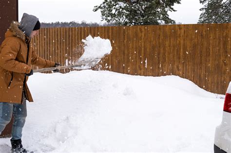 겨울에 한 남자가 주차장에있는 집 마당에서 삽으로 눈을 청소합니다 강설량 어려운 기상 조건 차가 멈추고 통로를 파고 있습니다 1월에 대한 스톡 사진 및 기타 이미지 Istock