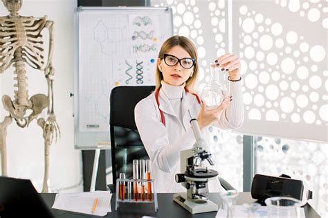 플라스크에 액체 용액을 들고 아름다운 여성 과학 연구원 또는 의사 유리 플라스크에서 새로운 물질을 관찰 매력적인 어린 소녀 박사 과정 학생 과학자 과학 헬스케어 개념