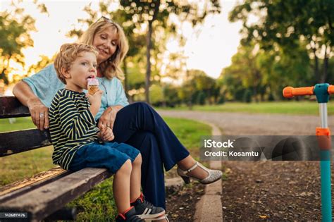 한 노인 여성이 공원 벤치에서 어린 소년 옆에 앉아 있다 아이스크림에 대한 스톡 사진 및 기타 이미지 아이스크림 사람들 즐거움 Istock
