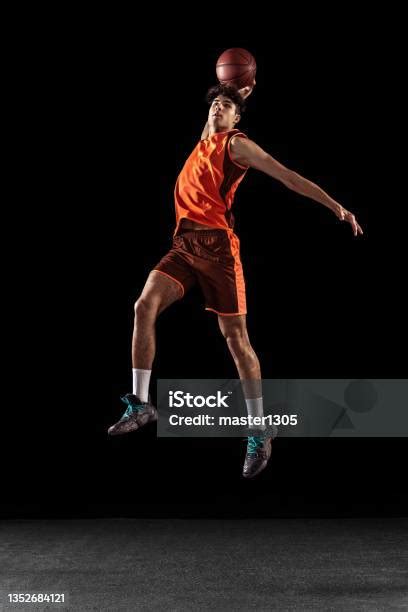 어두운 스튜디오 배경에 고립 된 농구 선수 훈련의 전체 길이 초상화 키가 큰 근육질 운동 선수가 공을 가지고 점프합니다 18 19세에 대한 스톡 사진 및 기타 이미지