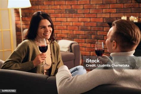와인 한 잔을 들고 집 벽난로 근처에서 함께 시간을 보내는 행복한 사랑스러운 커플 거실에 대한 스톡 사진 및 기타 이미지 거실 명랑한 벽난로 Istock