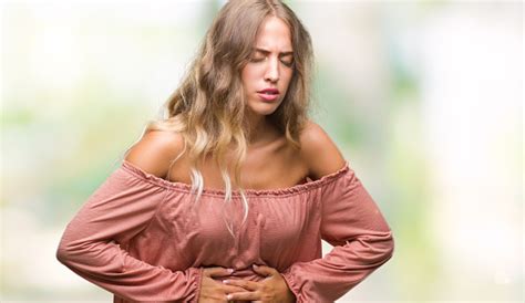 통해 아름 다운 젊은 금발의 여 자가 절연 배경 속에 손으로 하기 때문에 소화 불량 고통 스러운 질병 기분이 나쁘다 통증