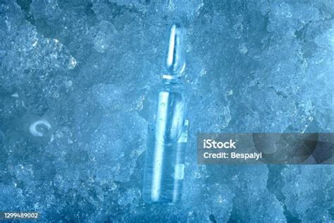 바이러스 성 질병의 치료를위한 의료 준비와 투명 액체와 유리 투명 앰플에 백신은 냉동 얼음에 누워 영하 온도에 냉각 제약에 파란색 배경 0명에 대한 스톡 사진 및 기타