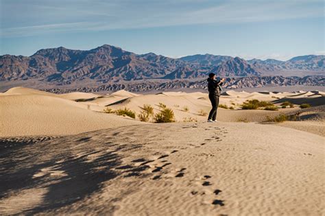 메스키트 플랫 데스 밸리 캘리포니아에서 모래 언덕에 하이킹 여자 가는 길에 스마트폰으로 사진을 찍는 다 건조 기후에 대한 스톡 사진 및 기타 이미지 Istock