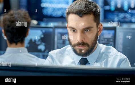 Neural Network And Machine Learning Engineer Programming At His Workstation Office Is Crowded