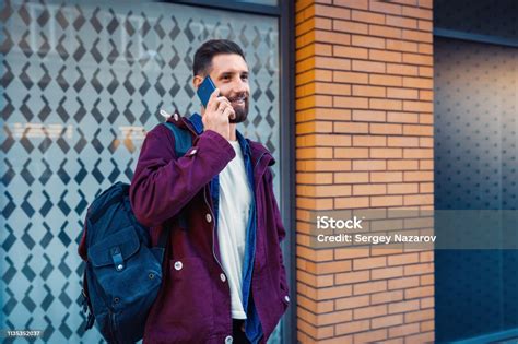 젊은 남자는 자신의 손에 스마트 폰으로 겨울 옷을 입고 거리에서 산책 가을에 대한 스톡 사진 및 기타 이미지 가을 거리 겨울 Istock