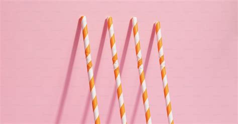 분홍색 배경에 세 개의 주황색과 흰색 줄무늬 빨대 사진 Unsplash의 밀 짚 이미지