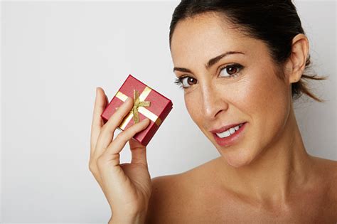 흰색 빈 배경 위에 손으로 빨간 선물 상자를 들고 검은 머리와 아름 다운 갈색 머리 여자의 패션 글 래 머 사진 긍정적인 인간의 감정 반응 제스처입니다 갈색 머리에 대한