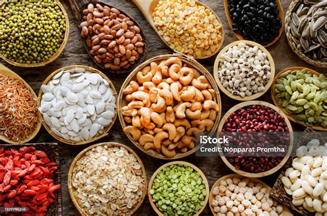 건강하거나 깨끗한 식품 성분 또는 농산물 컨셉을 위해 나무 그릇에 마른 유기농 시리얼과 곡물 씨앗의 다양한 종류 0명에 대한